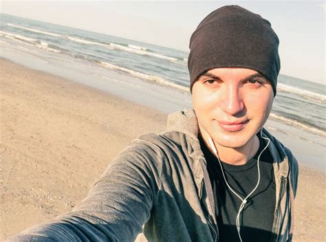 Молодой красивый парень с мужским спортом одевает принимать Selfie