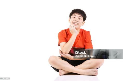 초상화 젊은 아시아 소년 흰색 배경 위에 앉아 빨간 티셔츠를 입고 십 대 소년의 전체 길이 감정 초상화 사려깊은 십 대 흰색