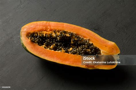 파파야 과일의 절반은 반으로 잘라 검은 현대 배경에 거짓말 달콤한 오렌지 파파야의 검은 씨앗 채식주의 건강한 영양 다이어트 열대 과일 맨 위 보기 공간을 복사합니다 플랫