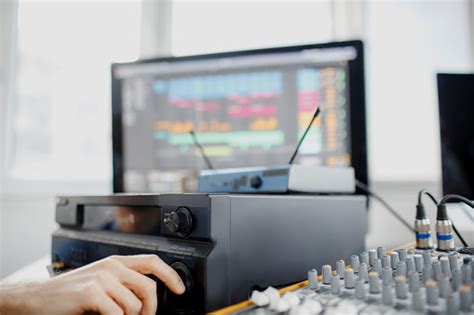 남성 음악 편곡자는 디지털 녹음 스튜디오에서 미디 피아노와 오디오 장비에 노래를 작곡하는 사운드 앰프와 함께 작동합니다 방송