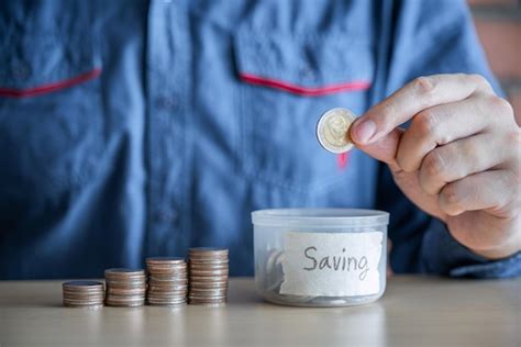 Premium Photo Midsection Of Person Inserting Coin In Container On Table Indoors