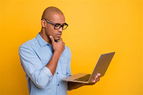 사진 검색 웹사이트 노트 노트 세심 한 손 턱 착용 사양 청바지 데님 셔츠 고립 된 밝은 노란색 배경 교사 교육 관련 직업에