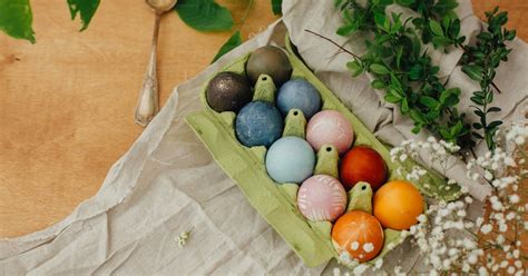 현대 노란색 분홍색 파란색 및 회색 부활절 달걀은 유기농 양파 사탕무 붉은 양배추 카케이드 차로 칠해져 있습니다 제로 웨이스트 휴가 꽃을 가진 소박한 테이블에