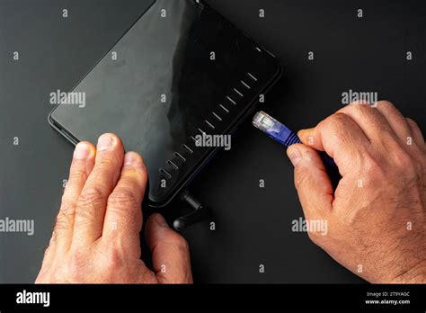 Man S Hand Plugging Internet Cable Into Wifi Router Stock Photo Alamy