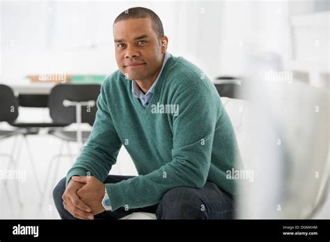 Business A Man Sitting Hands Clasped In A Relaxed Confident Pose