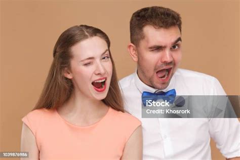 잘생긴 남자와 아름 다운 여자 또는 젊은 부부와 재미 있는 얼굴 입을 열고 윙크 카메라 보고의 근접 촬영 초상화 2명에 대한