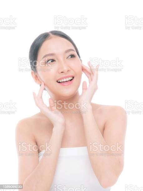 아름다운 젊은 아시아 여자 터치 그녀의 얼굴 와 깨끗한 피부 신선한 피부 흰색 배경에 얼굴 치료 화장품 아름다움과 스파 개념