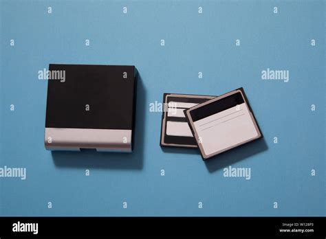 Two Digital Memory Cards For A Camera Compact Flash And Reader On Blue Background Stock Photo