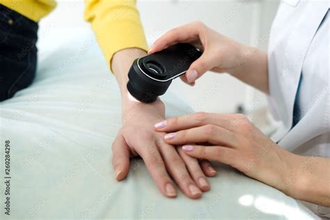 Female Dermatologist Using A Professional Dermatoscope While Doing Skin