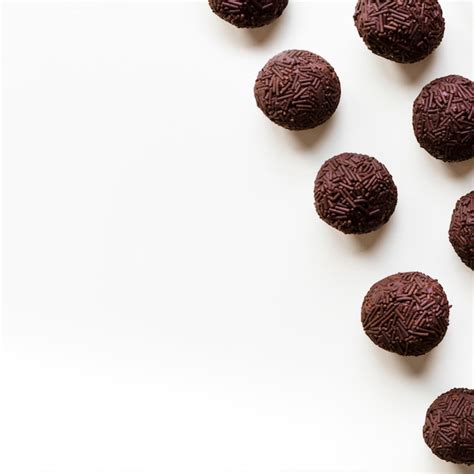 Trufas De Chocolate En Una Fila En El Fondo Blanco Foto Gratis