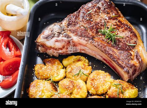 Prime Cut Of Steak With Baked Potatoes Served In Metal Tray Seasoned