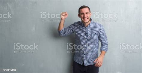 분노와 좌절 하 고 분노와 함께 외치는 동안 분노 주먹 양육 화 회색 그런 지 벽에 젊은 백인 남자 분노와 공격적 개념 감정에 대한 스톡 사진 및 기타 이미지 Istock