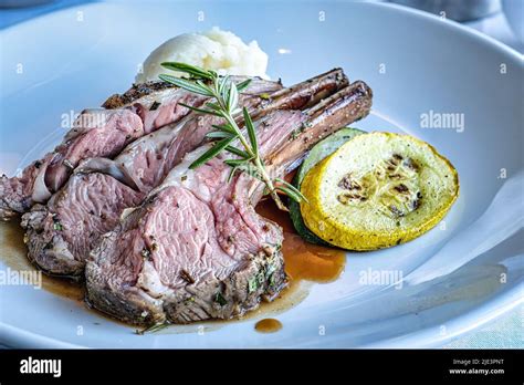 Medium Rare Lamb Chops On Plate With Grilled Squash And Mashed Potatoes