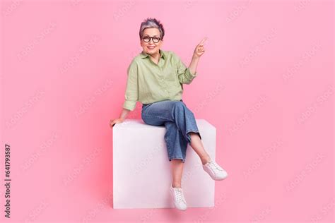 Full Body Photo Of Cheerful Friendly Person Sit Podium Indicate Finger