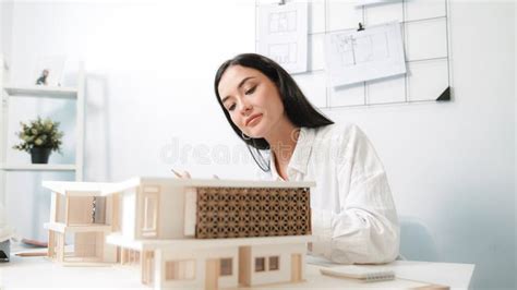 Professional Architect Using Triangular Scale Measure House Model
