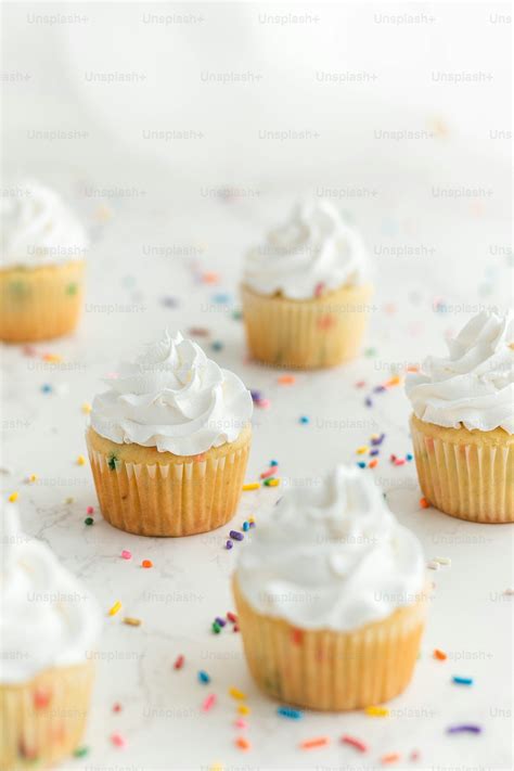 흰색 설탕을 입힌 컵 케이크와 테이블에 뿌린다 사진 Unsplash의 디저트 이미지