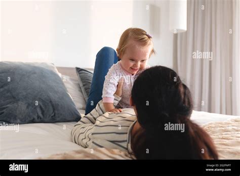 Portrait Of Caucasian Mother Playing With Her Baby Lying On The Bed At Home Stock Photo Alamy