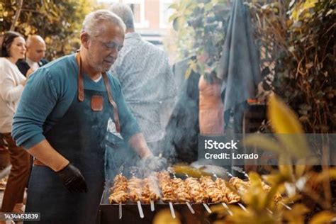 야외 그릴에서 바베큐 음식을 준비하는 잘 생긴 중년 남자 Barbecue Social Gathering에 대한 스톡 사진 및 기타 이미지 Barbecue