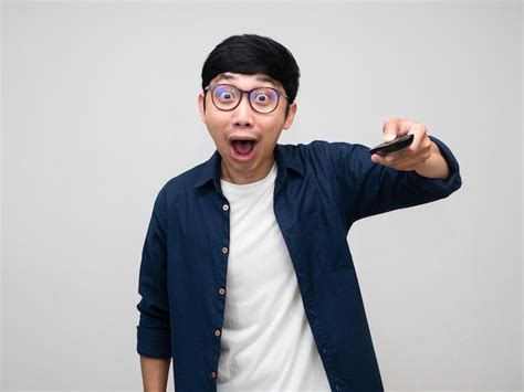 아시아 남자는 고립된 손에 프레스 원격 Tv로 흥분을 느낀다 프리미엄 사진