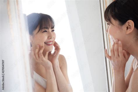 笑顔で鏡を見る女性 Stock 写真 Adobe Stock