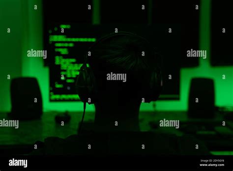 Hacker Man Looks At The Screen There Are Green Texts On The Black Screen Hacker Writes Code