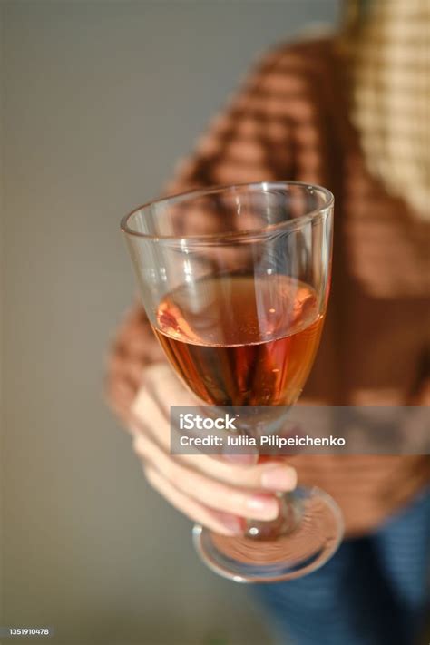 집에서 태양에 여자의 손에 와인 유리 알코올 음료의 맛 축하하고 순간을 즐길 수 있습니다 낭만적 인 저녁 감전 와인 클로즈업