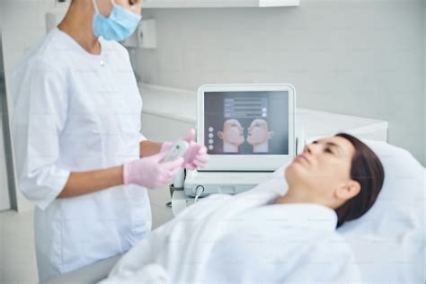 라텍스 장갑을 끼고 얼굴에 마스크를 쓴 집중 미용사가 손에 미용 기기를 응시하고 있다 사진 Unsplash의 백인 이미지