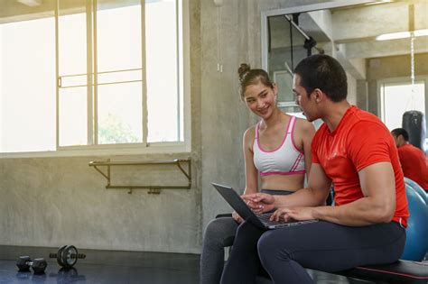 여자는 트레이너와 함께 피트 니스를 논의 하 고 체육관에서 운동 중에 이야기 하는 젊은 여성 여성 코치 노트북 또는 컴퓨터 지시문을 설명입니다 모금에 대한 스톡 사진 및