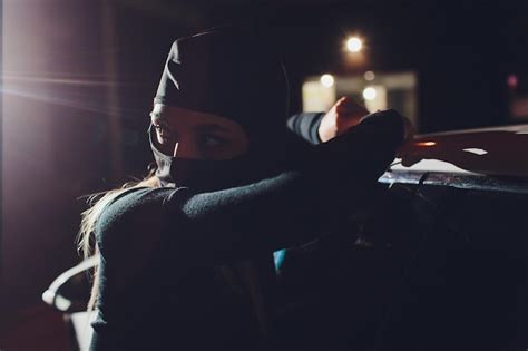 Premium Photo Masked Robber Woman Car The Thief Is Levering The Lock