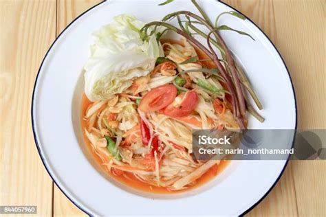 파파야 샐러드와 당근 렌즈콩 토마토 말린 새우 고추 나무 배경에 흰색 접시에 태국 스타일 음식입니다 건강한 식생활에 대한 스톡