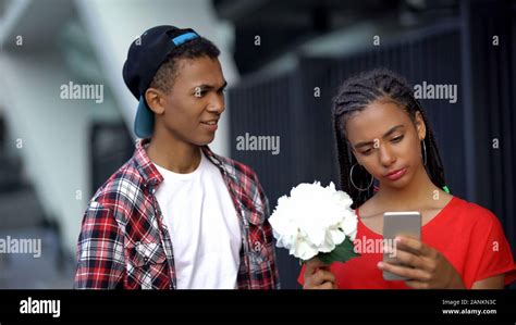 Teen Girl Ignoring Flowers From Boy Preferring Social Networks