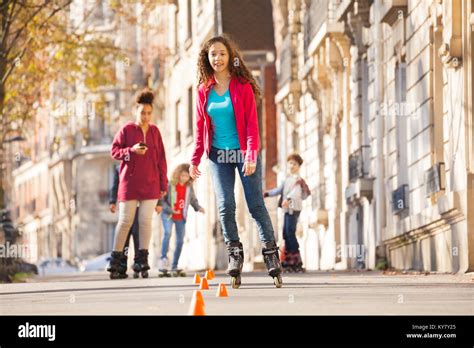 Portrait Of Teenage Girl Rollerblading Around The Cones At City Side