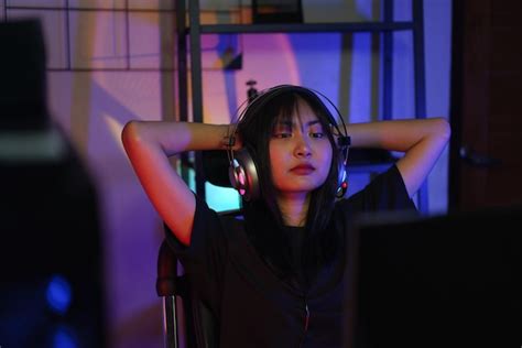 Premium Photo Female Cyber Hacker Gamer Holds Hands Behind Head To