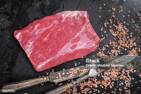 조리되지 않은 생 플랩 측면 쇠고기 고기 스테이크를 식탁에 올려놓고 있습니다 검은 색 배경 위쪽 보기 0명에 대한 스톡 사진 및