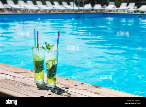 Two Mojito Cocktail With Lime And Mint In Highball Glass At The Swiming