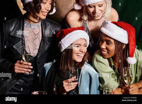 Carefree Multicultural Girlfriends In Christmas Hats Celebrating New