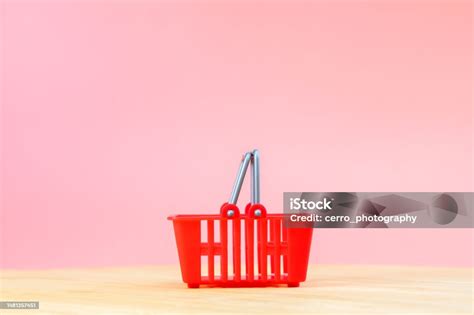 분홍색 배경에 빈 빨간 쇼핑 바구니 나무 테이블에 식료품 쇼핑을 위한 슈퍼마켓 배경 홀에 제품과 음식이 있는 밝은 상점 초점이