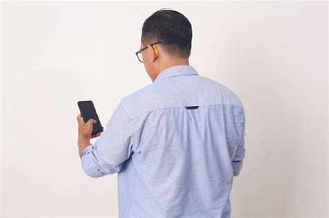 밝은 파란색 셔츠를 입고 휴대 전화 화면을 바라 보는 성인 아시아 남성의 뒷모습 흰색에 고립 됨 남자에 대한 스톡 사진 및 기타