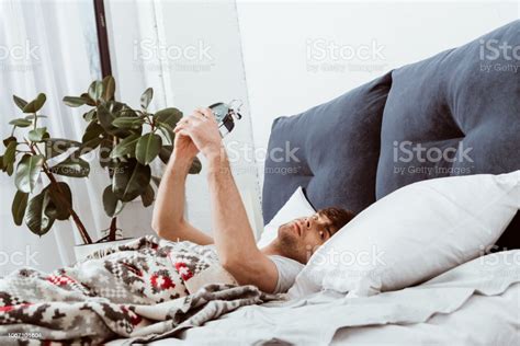 집에서 침대에서 알람 시계를 해제 하는 젊은 남자의 모습 담요에 대한 스톡 사진 및 기타 이미지 담요 백인종 벽 시계