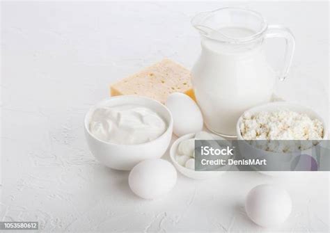 흰색 테이블 배경에 신선한 낙농 제품입니다 유리 항아리 우유 크림 및 코 티 지 치즈와 모 짜 렐 라의 그릇 에 계란 그리고