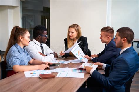 Multiracial Team Analyzes Graphs In Office African Man In Suit Shares