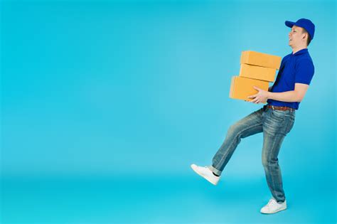 파란색 배경에 고립 된 종이 소포 상자를 들고 아시아 행복 배달 남자 우편 배달 서비스의 개념 아시아인에 대한 스톡 사진 및