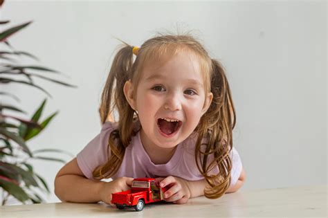 작은 빨간 장난감 자동차와 함께 재생 작은 귀여운 소녀 실내에서 화려한 빨간 자동차와 건강한 행복 유아 어린 소녀는 웃음 2 3 살에 대한 스톡 사진 및 기타 이미지