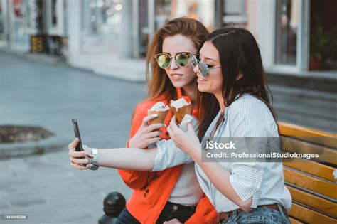 젊은 여자 친구는 시내 중심에 앉아서 차가운 아이스크림을 즐기고 셀 카를 복용 합니다 먹기에 대한 스톡 사진 및 기타 이미지 먹기 아이스크림 커플 Istock