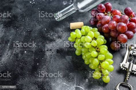 녹색과 빨간색 포도 병 코르크 나사 코르크의 가지 와인 제조의 개념 검은 색 배경 맨 위 보기입니다 복사 공간 0명에 대한 스톡