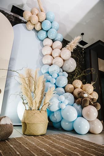 사진 벽 장식 공간 또는 베이지색 갈색 파란색 풍선이 있는 장소 축하 세례 개념입니다 소년을 위한 생일 파티 마른 나뭇잎이 있는 트렌디한 가을 장식 배경 풍선에 곰이 있는