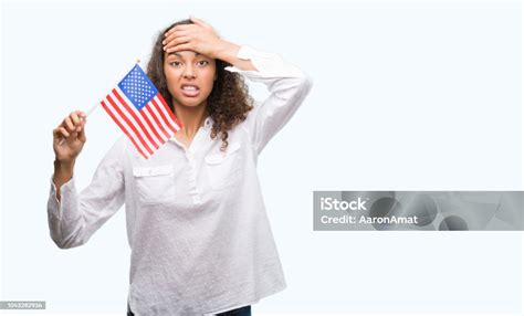 영지의 미국 손으로 머리 수치심과 놀라움으로 충격된에 강조의 젊은 스페인 여자 들고 국기 얼굴 분노와 좌절 두려워 하 고 실수에