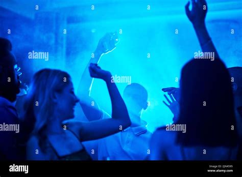 Let The Music Take Over A Crowd Of People Dancing Inside Of A Club At Night Stock Photo Alamy