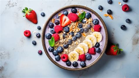 A Bowl Of Granola Topped With Sliced Bananas Strawberries And