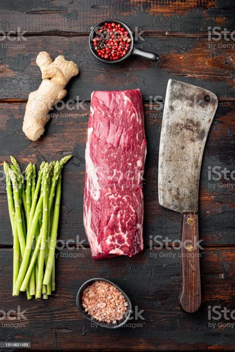 오래된 정육점 칼칼을 곁들인 생 신선한 대리석 쇠고기 필레의 미식가 부분 오래된 어두운 나무 테이블 배경 상단 보기 플랫 레이
